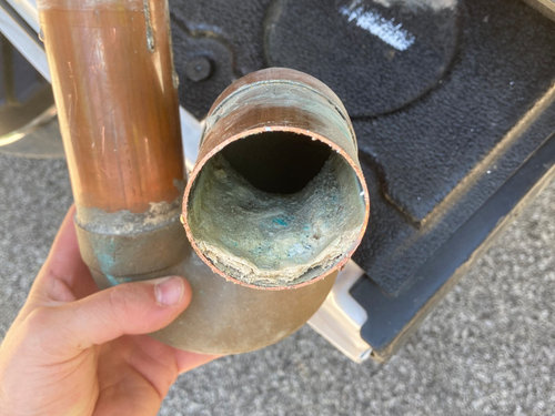 Plumber pushing to replace copper with PVC pipes in shower drain.