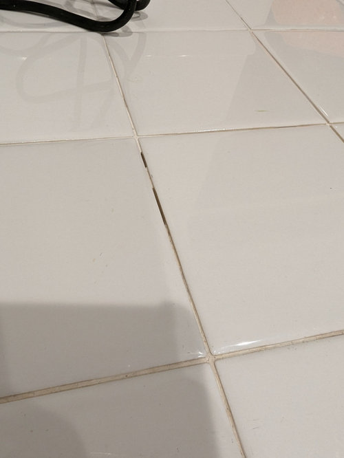 Chipped and worn-down grout on kitchen counter.