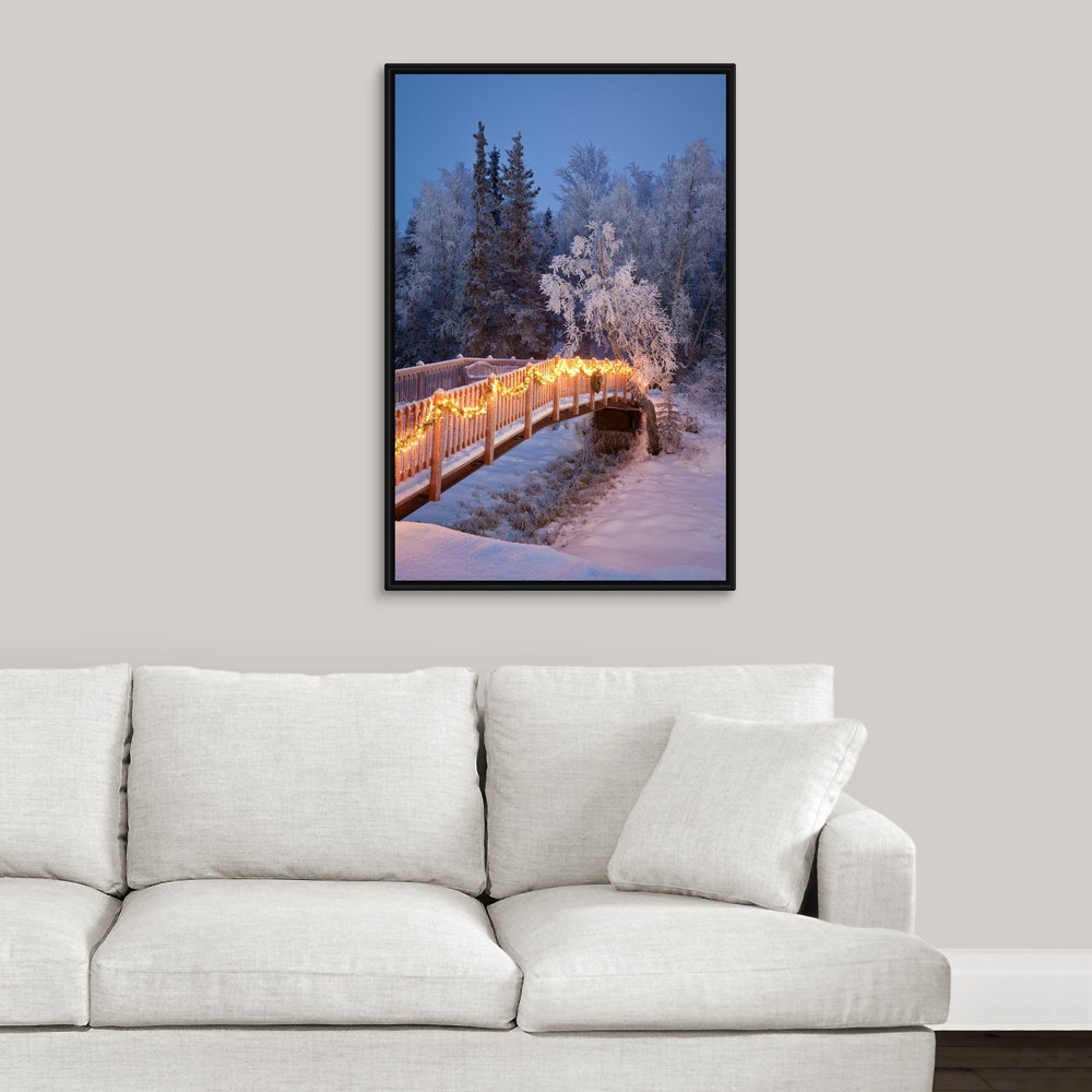 "Bridge decorated with Christmas lights in a forest setting ...