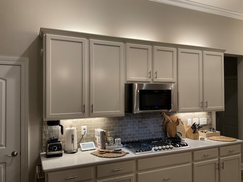 Above kitchen cabinets decor. The cabinets have up lighting.