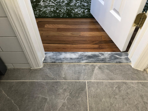 Chipped tile at door threshold in new bathroom. What to do?