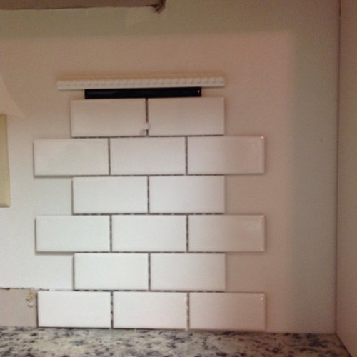 White 2x4 tile backsplash with black line accent