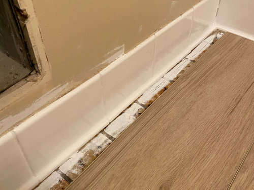 How to lay vinyl plank against cove base tiles?