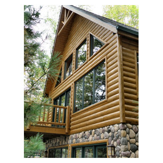 Half log hewn siding with a cedar railing around the deck - Rustic ...