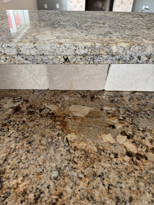 Backsplash in kitchen with white cabinets, warm granite