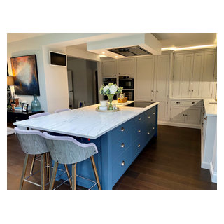 Dark blue kitchen island with white cabinets and integrated hob ...