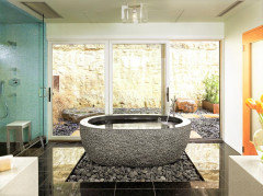 How do you install river rocks around the base of a freestanding tub?