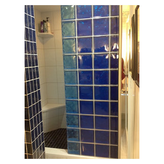 Multi colored glass block shower wall with Wedi corner bench seat in a ...