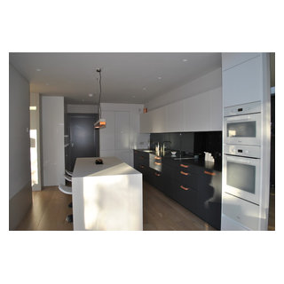Contemporary kitchen with dark graphite units, grey mirror splashback ...