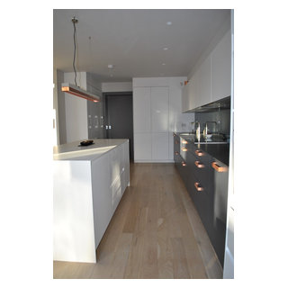 Contemporary kitchen with dark graphite units, grey mirror splashback ...