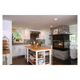 Three sided stone fireplace in this chef's kitchen - Beach Style ...