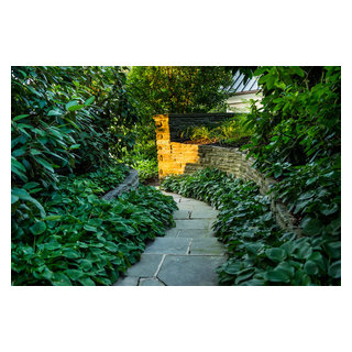 A stone stepped pathway is lined with lush, green plantings ...