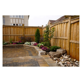 multi- level interlock patio with retaining walls and fencing - Modern ...