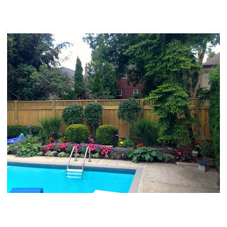 Pool side landscaping with a cedar fence and stone deck ...