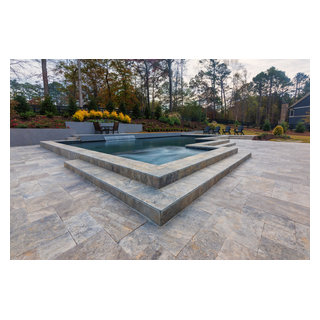 Contemporary style pool with silver travertine deck and custom water ...