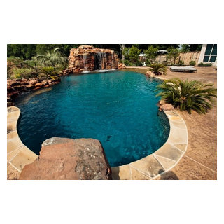 Lagoon style swimming pool with waterfall grotto with spa inside ...