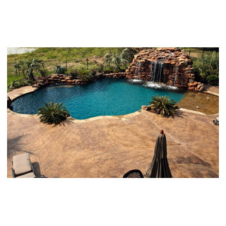 Lagoon style swimming pool with waterfall grotto with spa inside ...