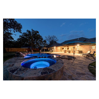 Rustic lagoon style pool with a fire pit, water falls and a hot tub ...