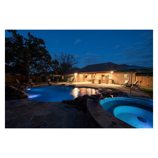 Rustic lagoon style pool with a fire pit, water falls and a hot tub ...