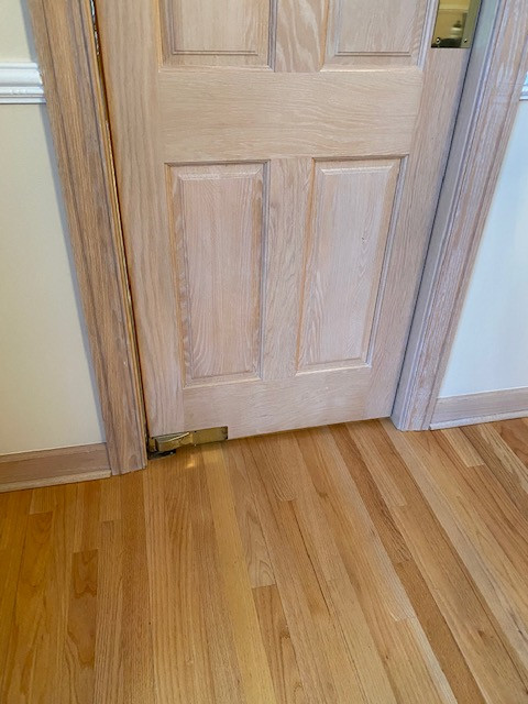 What color wood flooring with light wood baseboard, trim & doors