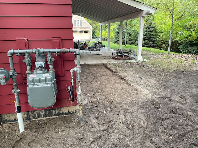 Gas line/meter sticking past house corner and in to driveway