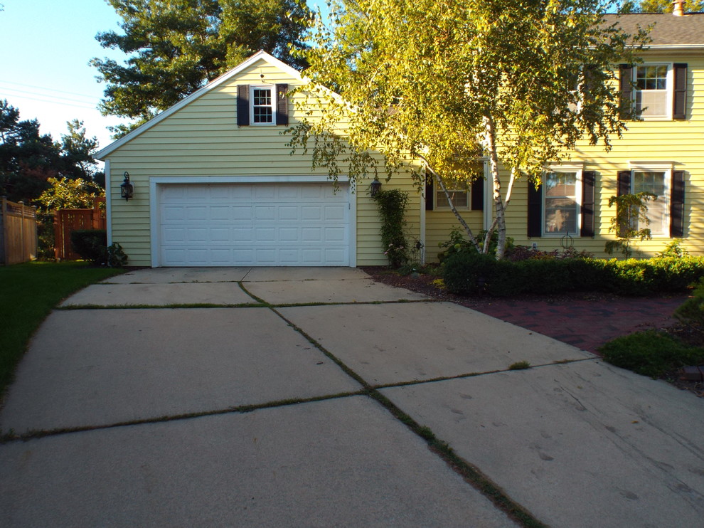 Plain vanilla garage door and concrete driveway