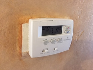 How can I conceal unpainted wall exposed by replacing thermostat?
