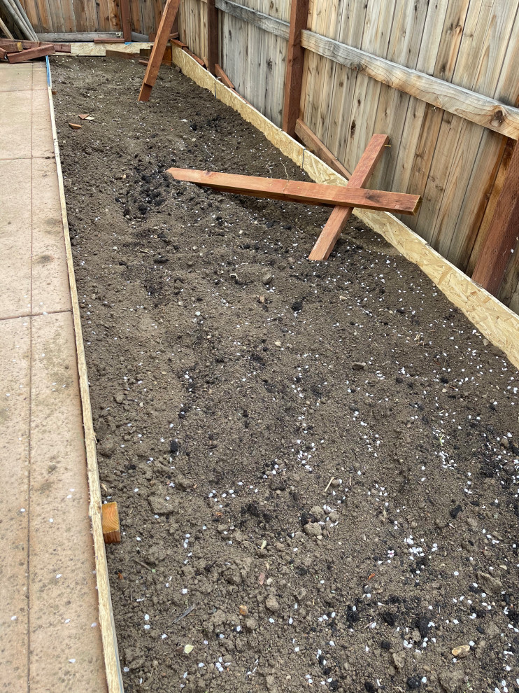 OSB board for garden bed and ground slope to the fence