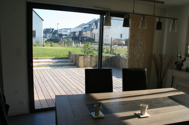 Traverse paysagère et terrasse bois devant une maison contemporaine ...