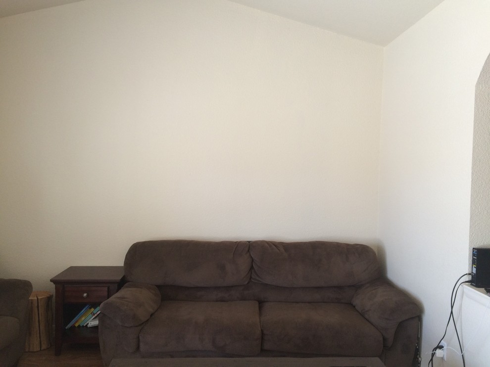 How can I decorate a wall above an off-center sofa?