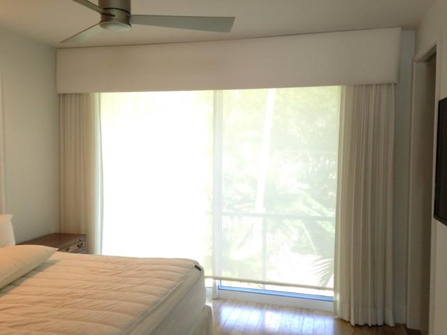 Bedroom with upholstered cornice with traversing sheer drapery ...