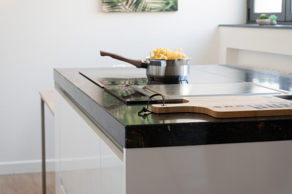 Cocina moderna, con isla y encimera de granito de cinco centímetros ...