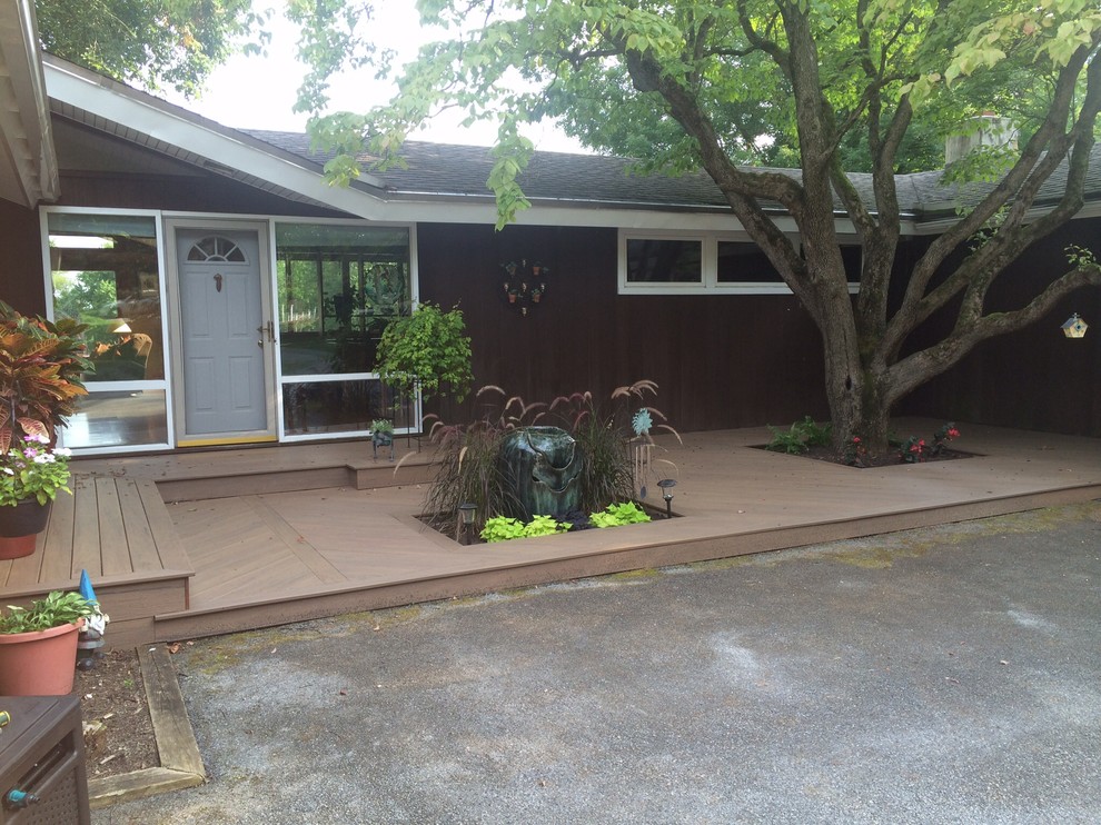 Timbertech Pecan deck built around tree, flower bed, and water feature ...