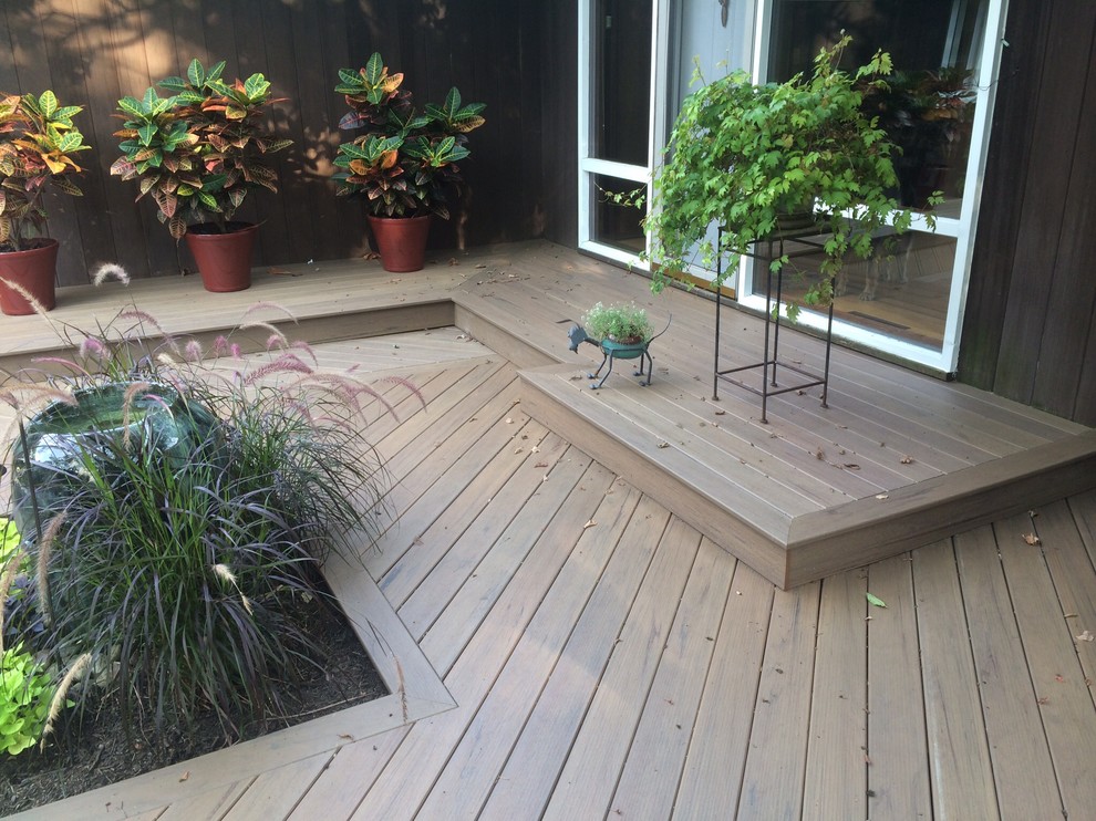 Timbertech Pecan deck built around tree, flower bed, and water feature ...