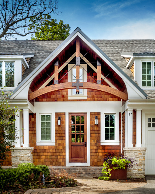 Front entry gable detail with rustic arched beams and iron brackets ...