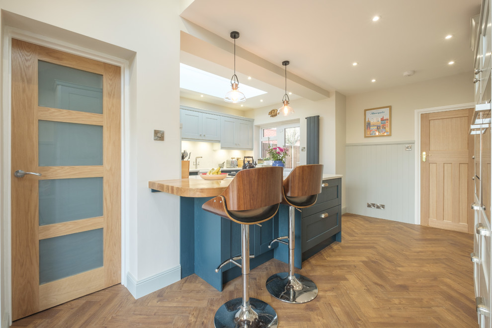 A chunky timber worktop in one corner of the island allows a neat ...
