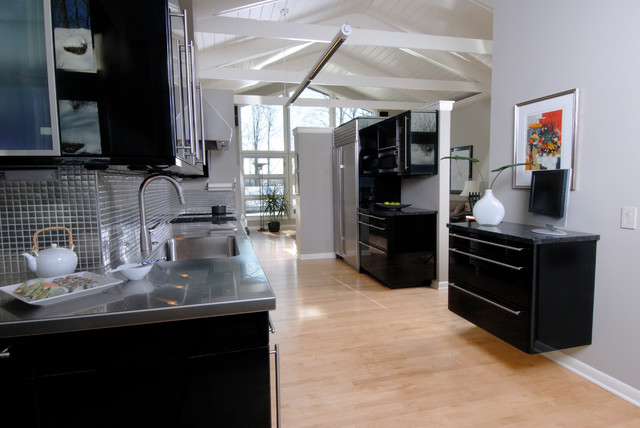A contemporary kitchen with vaulted ceilings and high gloss black ...