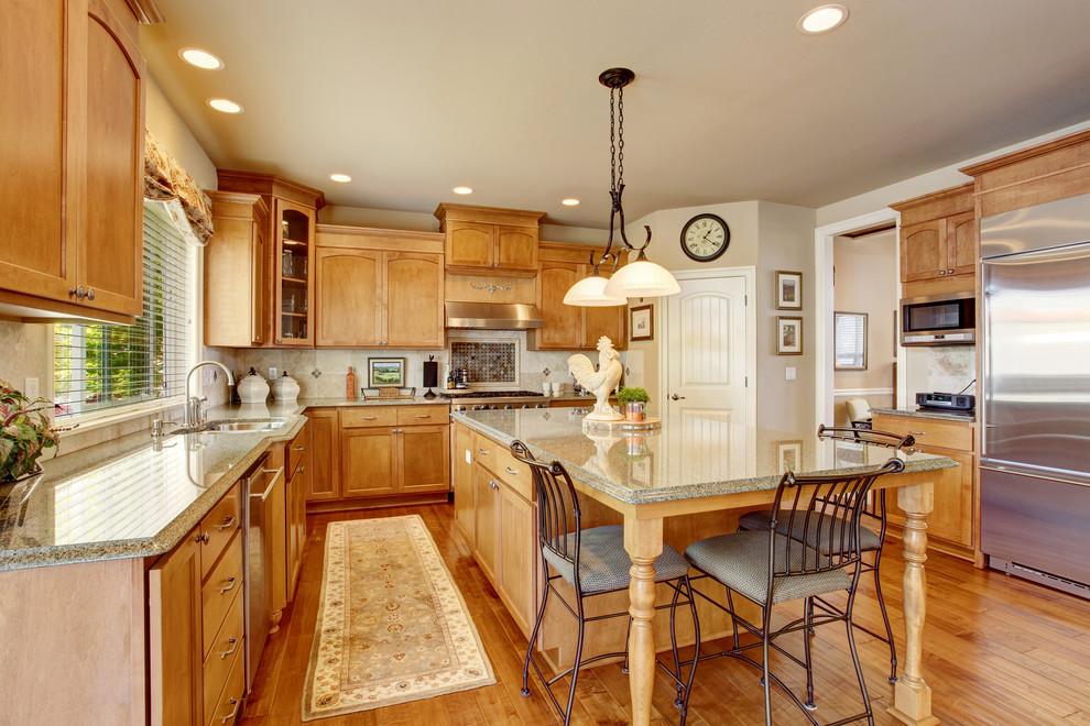 Classic American kitchen interior with brown cabinets granite counter ...