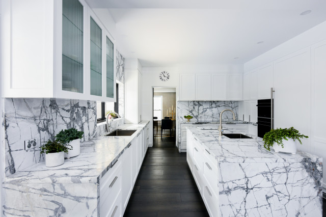 Kitchen with white shaker profile cabinets and marble benchtops ...