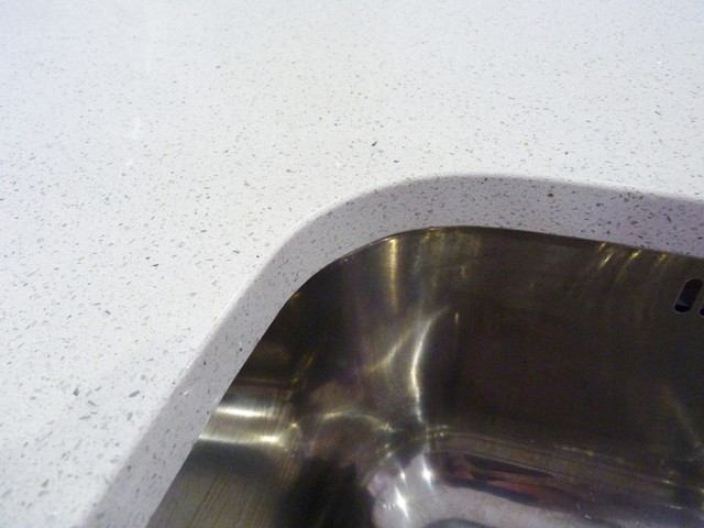 Gloss lacquered 'graphite' handleless kitchen with white quartz ...