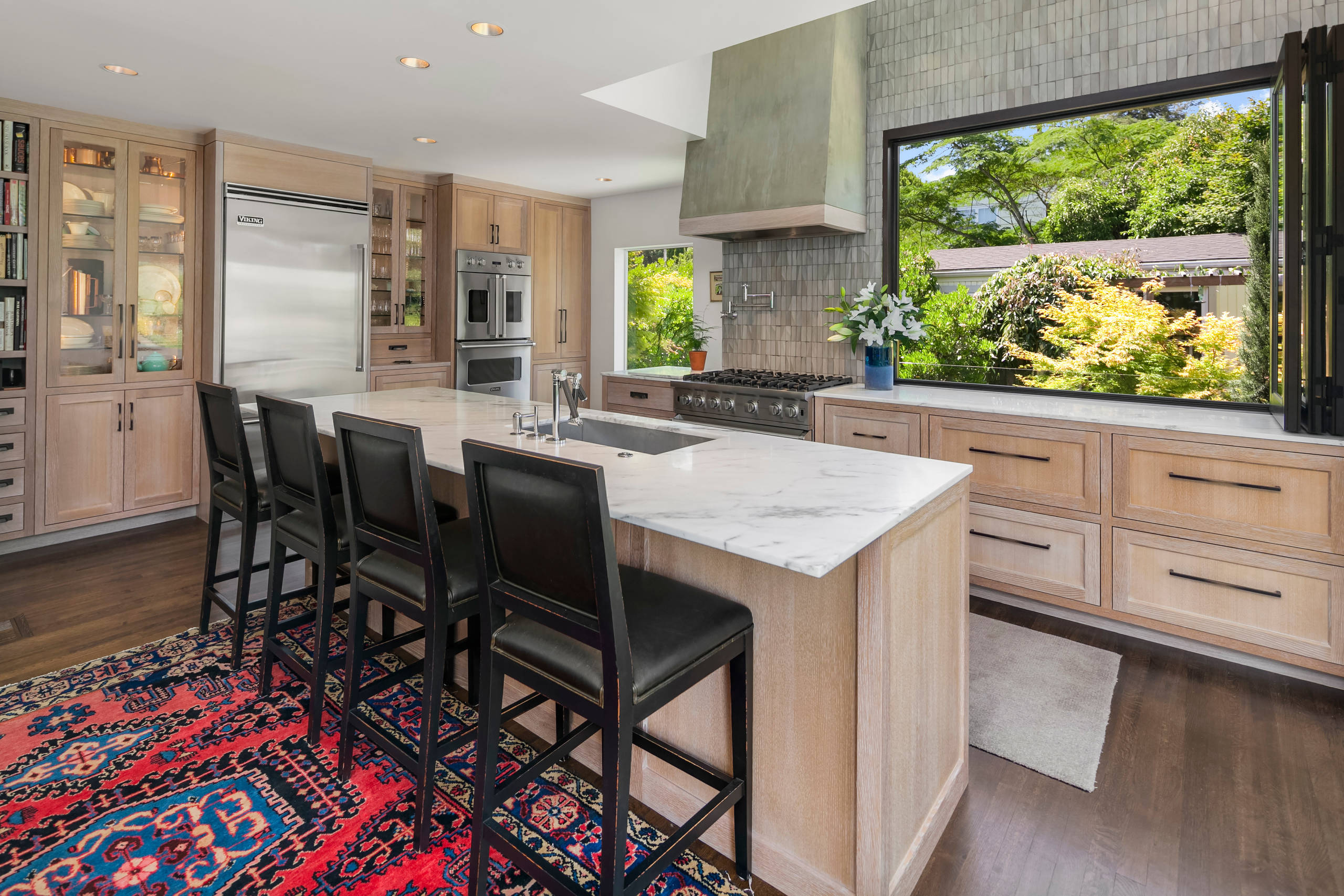 Oak Cabinets and a Stucco Hood Add Texture to This View Kitchen