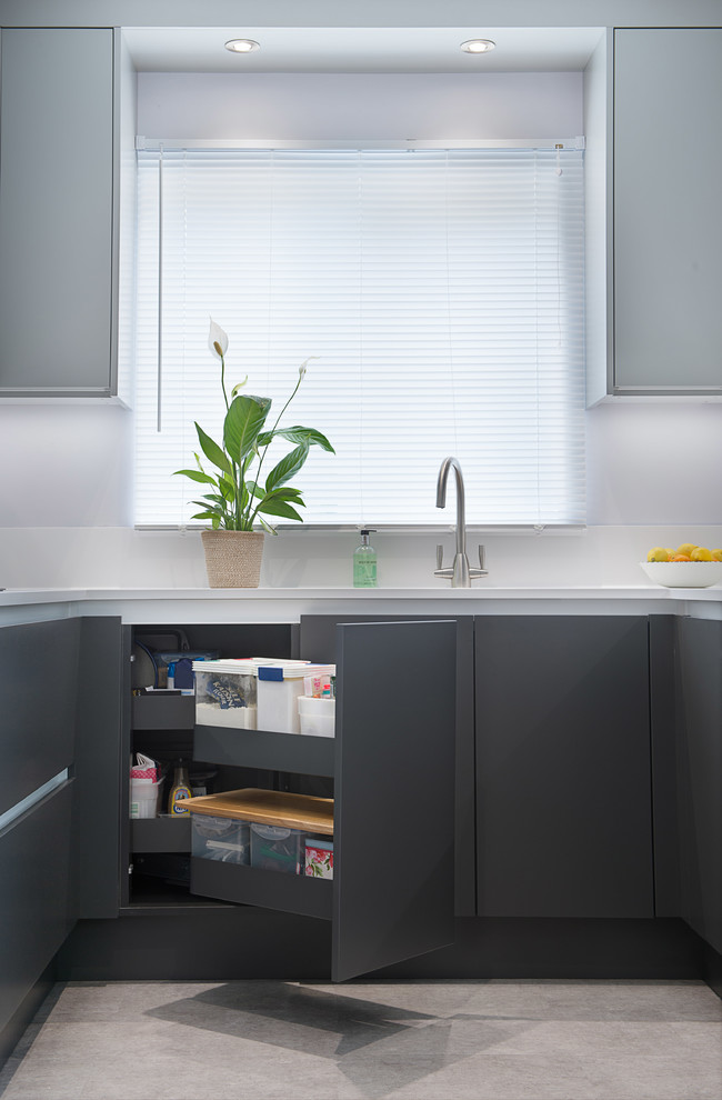 True handless monochrome panel door kitchen with Corian worktop ...