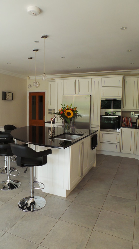White painted Shaker-style kitchen with polished stainless steel door ...
