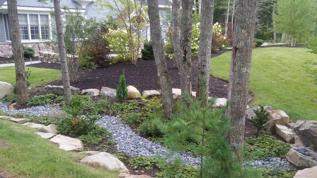 An extensive landscape project with stonewalls, patio, dry river bed ...