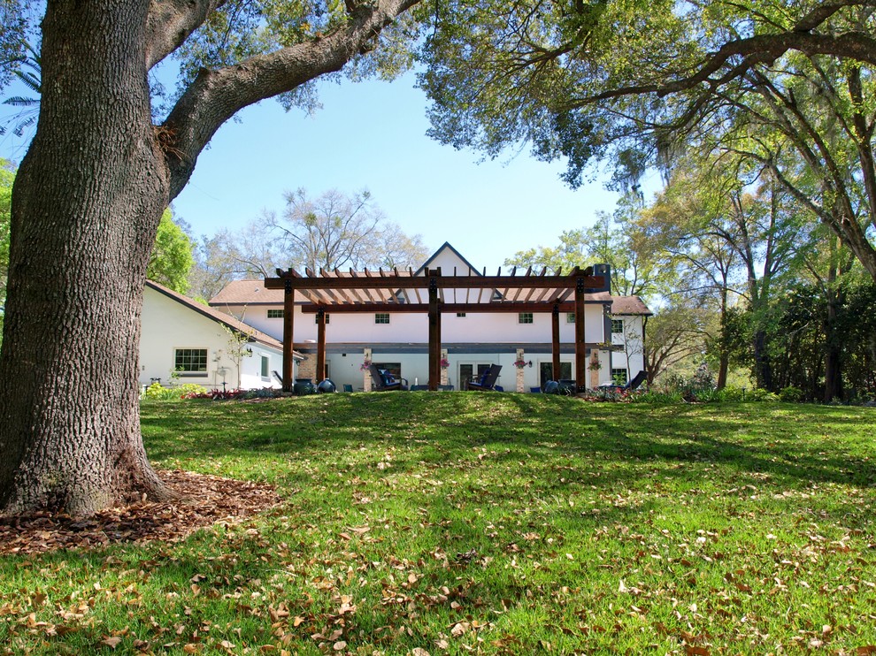 Backyard Tudor revival landscape along a natural area with a stream ...