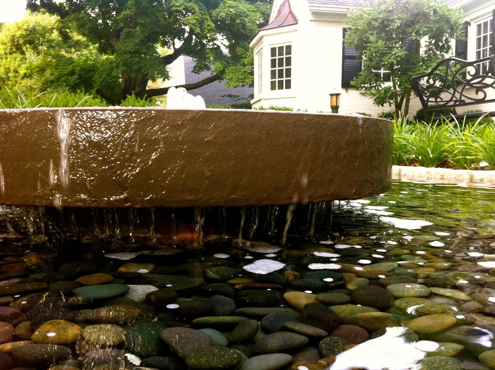 Polished bluestone millstone water feature with pebbles below. - Modern ...