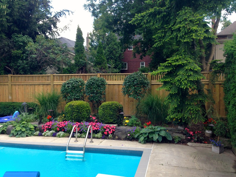 Pool side landscaping with a cedar fence and stone deck - Moderno ...