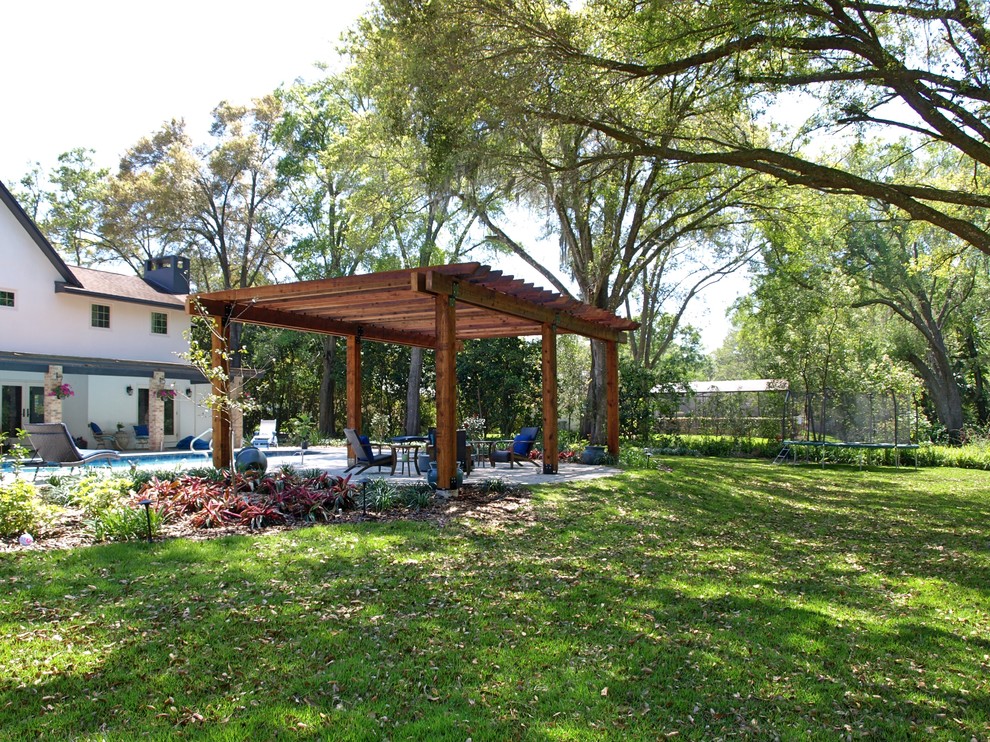Backyard Tudor revival landscape along a natural area with a stream ...