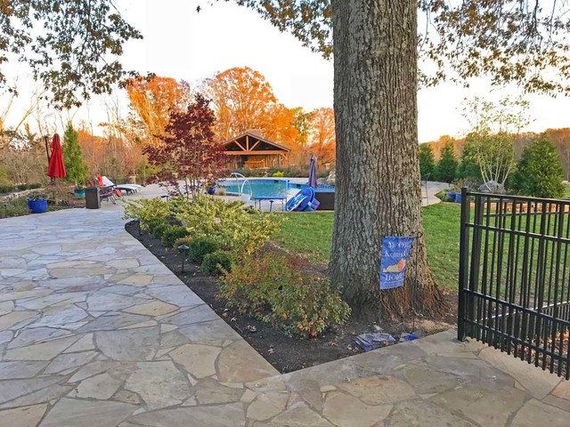 Completed after photo of backyard with flagstone patio, pool deck ...