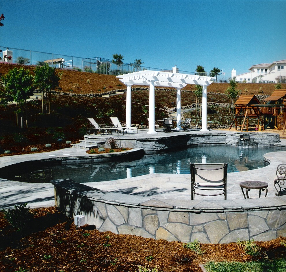 Free form pool with raised entertaining areas and spa with spill over ...